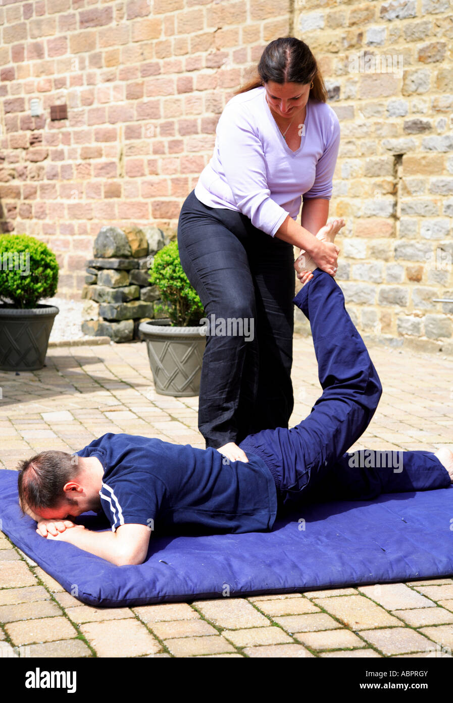 Leg and hip stretch as part of a Thai body massage Stock Photo - Alamy