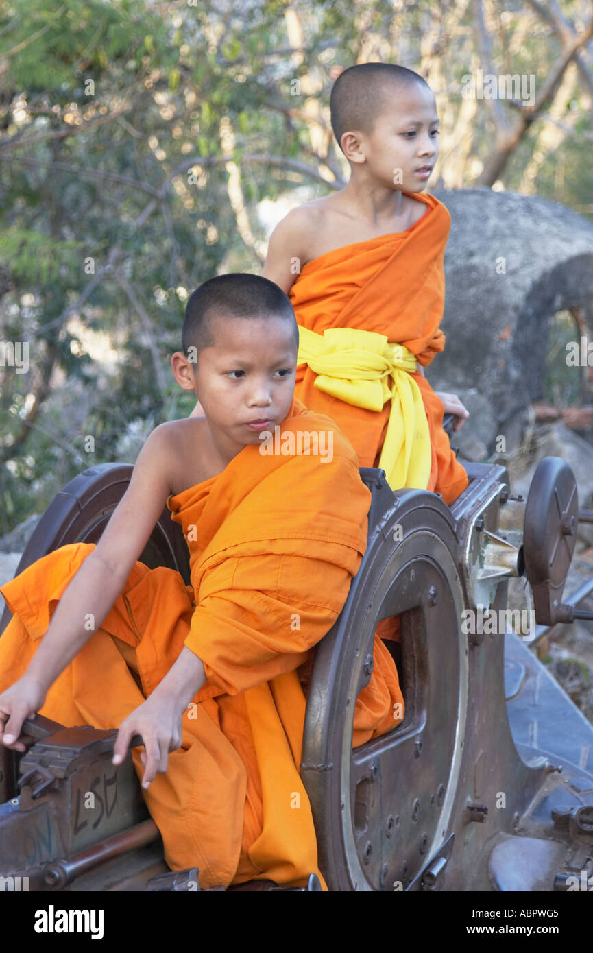 Monks Sitting On Disused Gun Stock Photo - Alamy