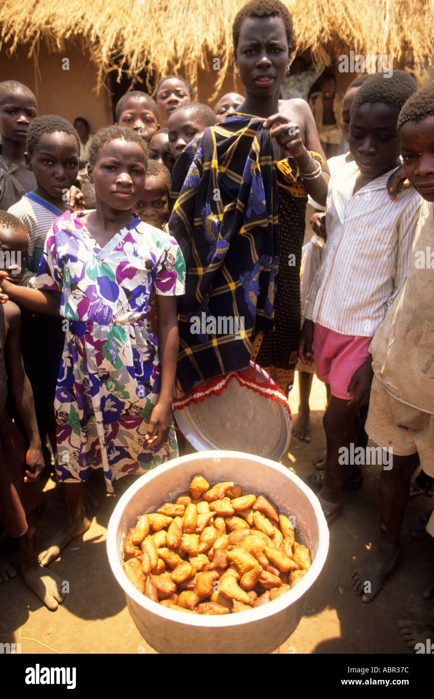Kalepo, Tanzania. Village group with deep-fried sweet sort of doughnuts ...