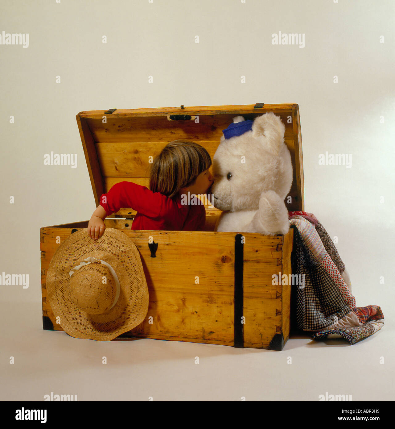 child kissing a big teddy hiding in a big wooden box. Photo by Willy ...