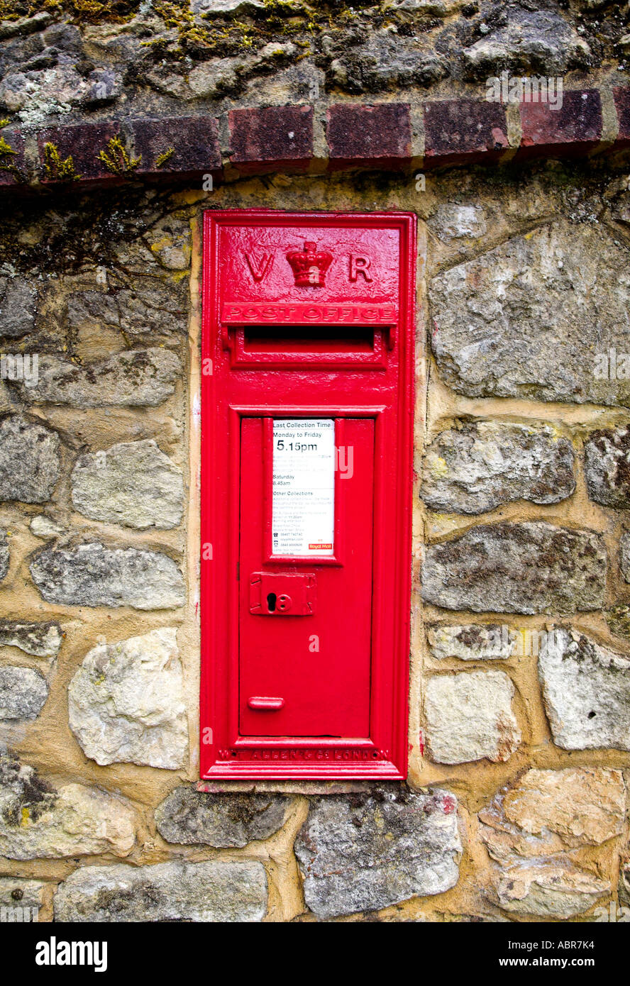 Vertical picture of an old Red Post box set into a stone wall Stock ...