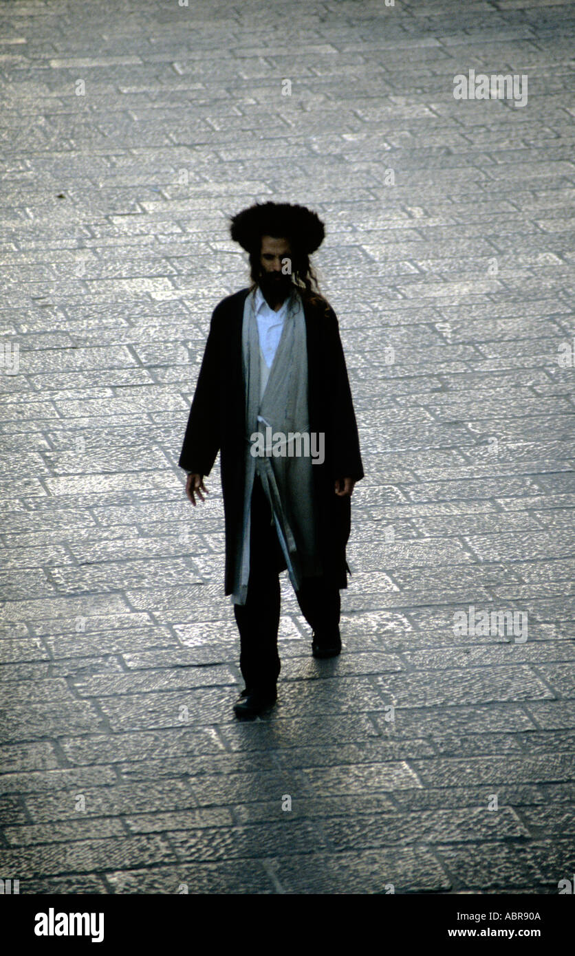 A Male Hasidic Jew walking by himself across the pavement Jerusalem ...