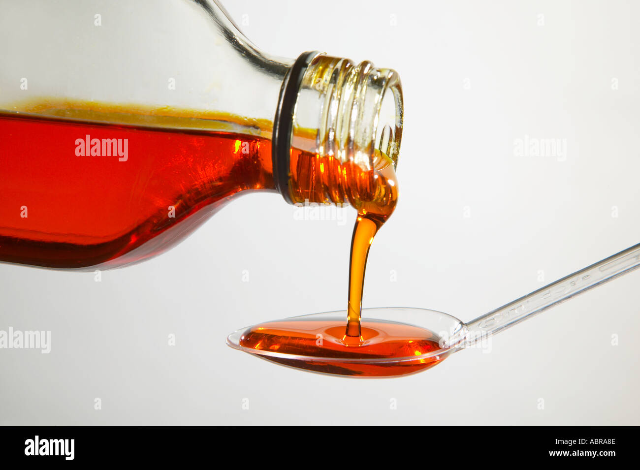 MEDICINE POURING FROM BOTTLE INTO PLASTIC SPOON Stock Photo - Alamy