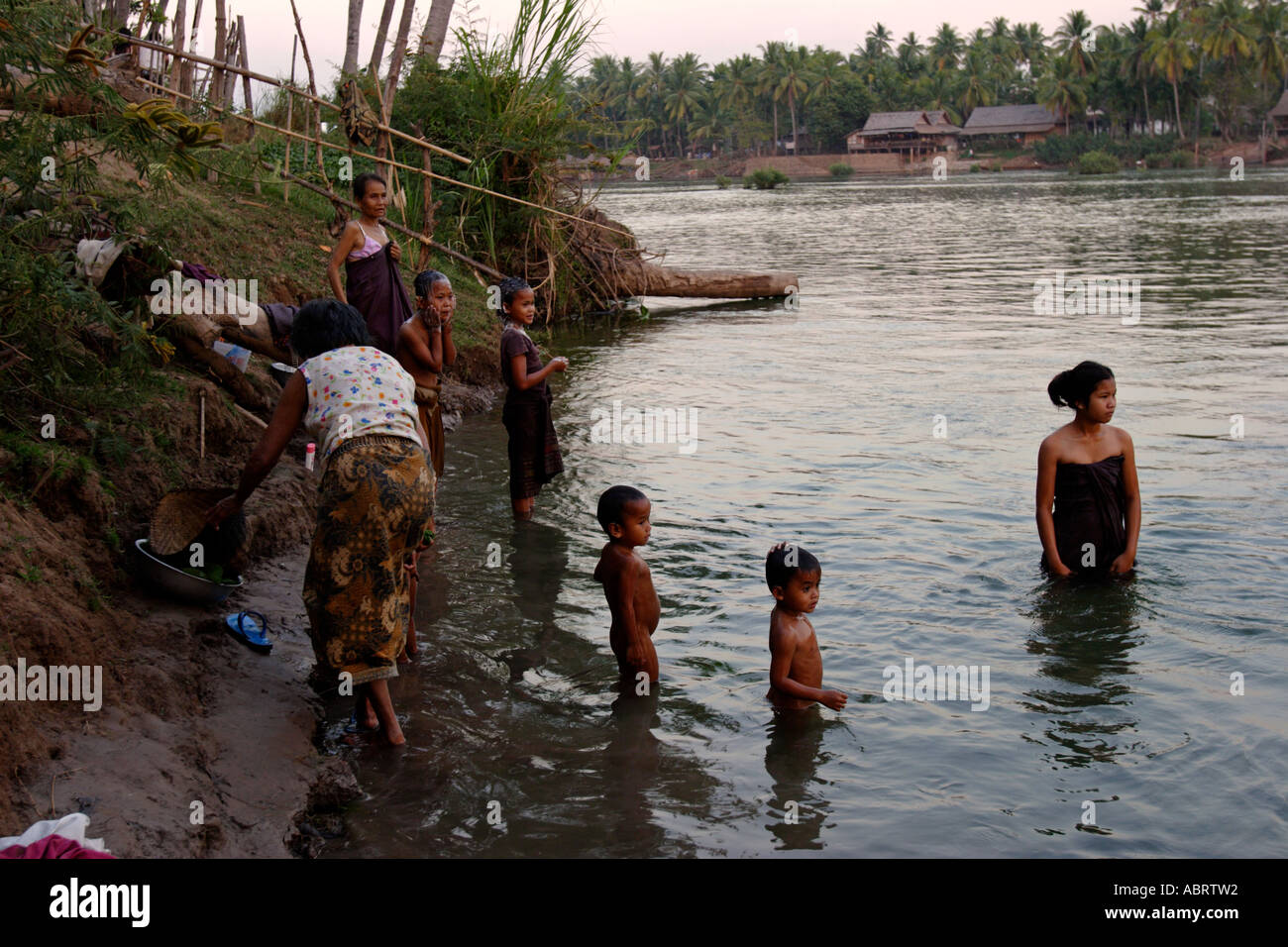 A Laotian family bathes in the Mekong river at Si Phan Don, also Stock ...