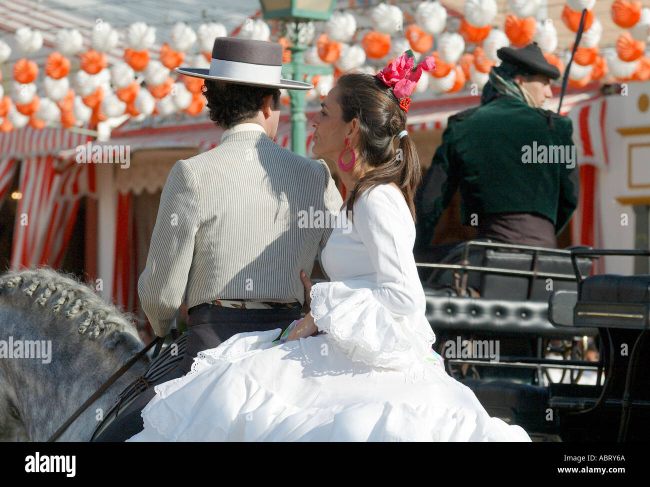 Man with girl in flamenco dress riding pillion outside a caseta at the ...