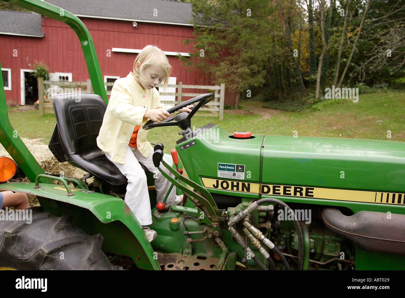 Young girl sitting on a tractor Stock Photo - Alamy