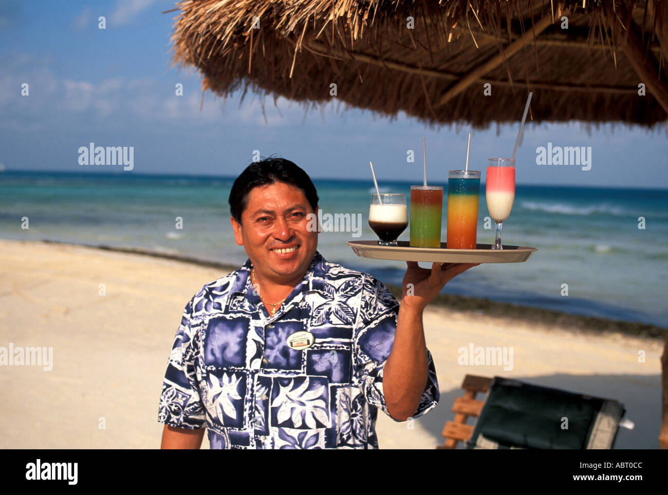 MEXICO Waiter on the beach with colorful drinks Stock Photo - Alamy