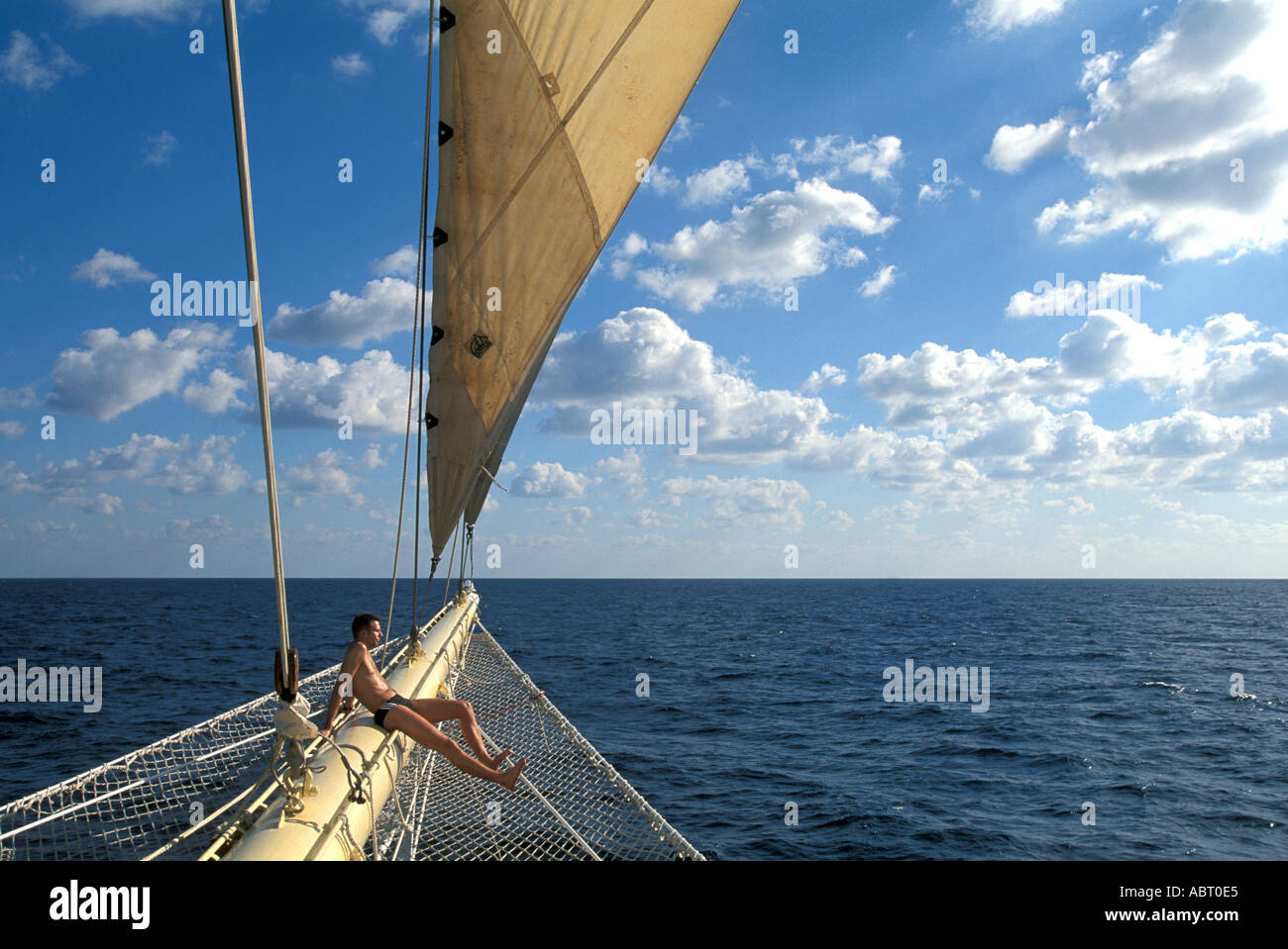 Cruising Man sitting on bow of sailing ship Windstar Stock Photo - Alamy