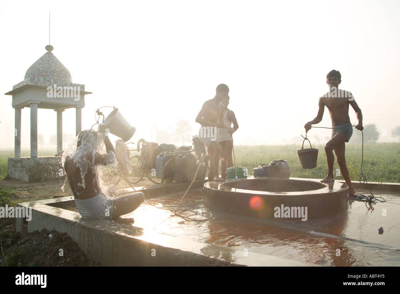 Men performing their daily dawn ritual washing using water from a well ...