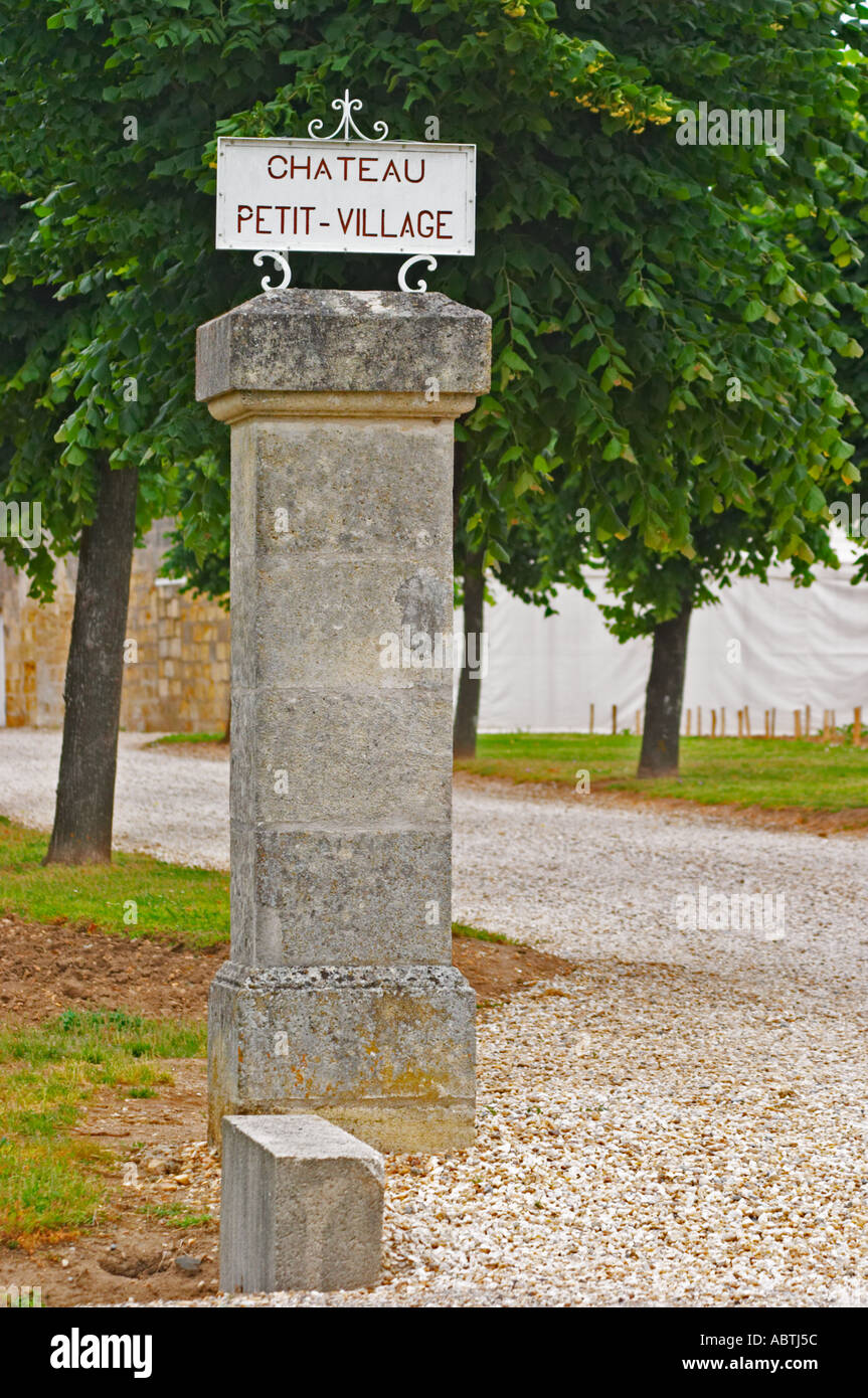 A stone gate post and a white sign saying Chateau Petit Village and the ...