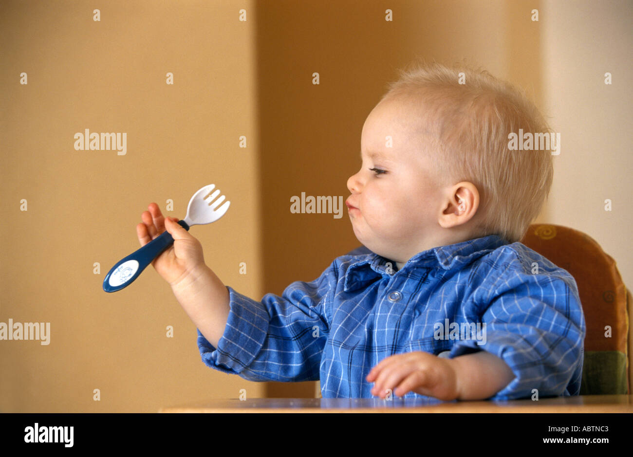 Toddler eating with a plastic fork Stock Photo - Alamy