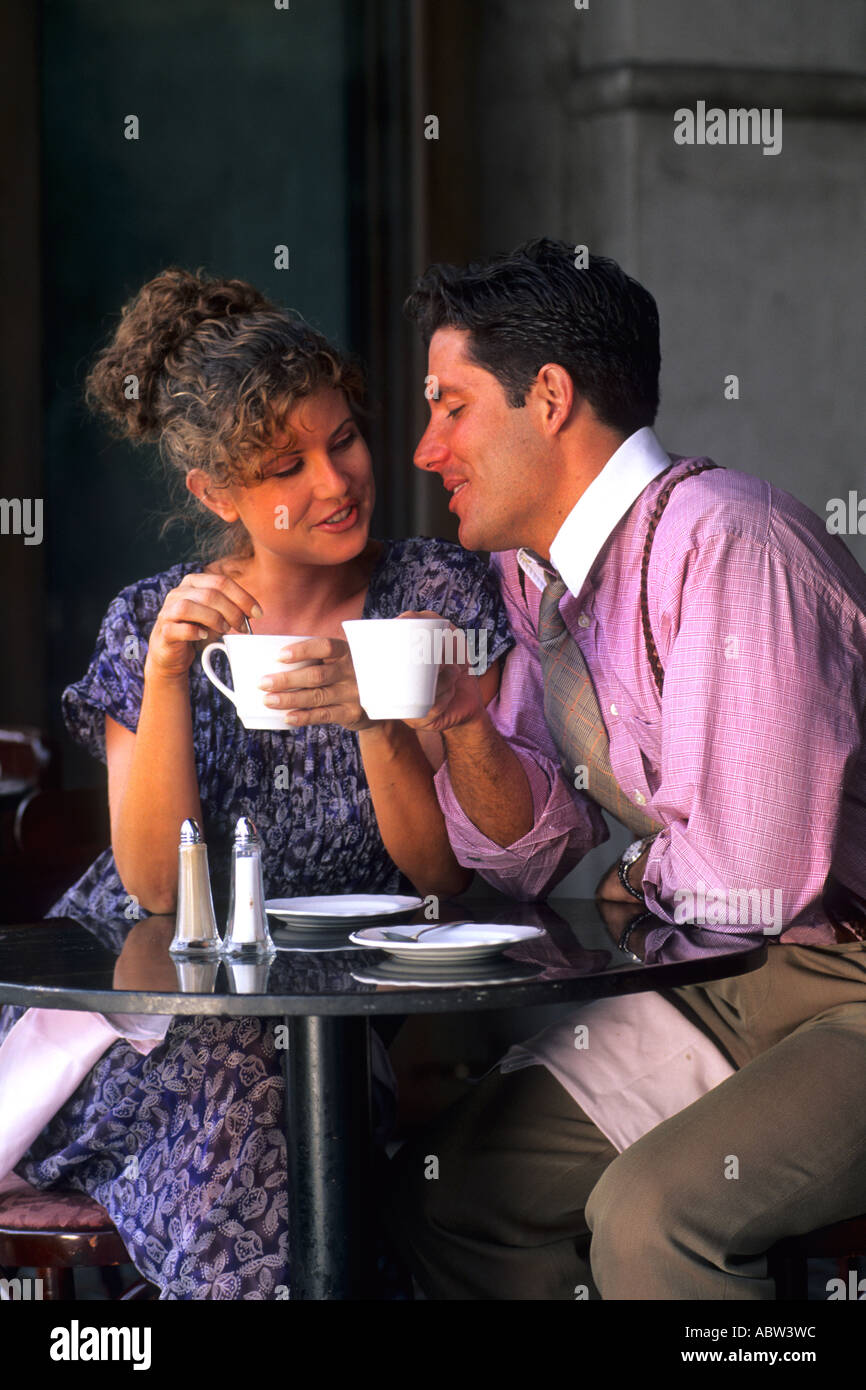 young attractive couple age 20s and 30s having coffee together in café ...