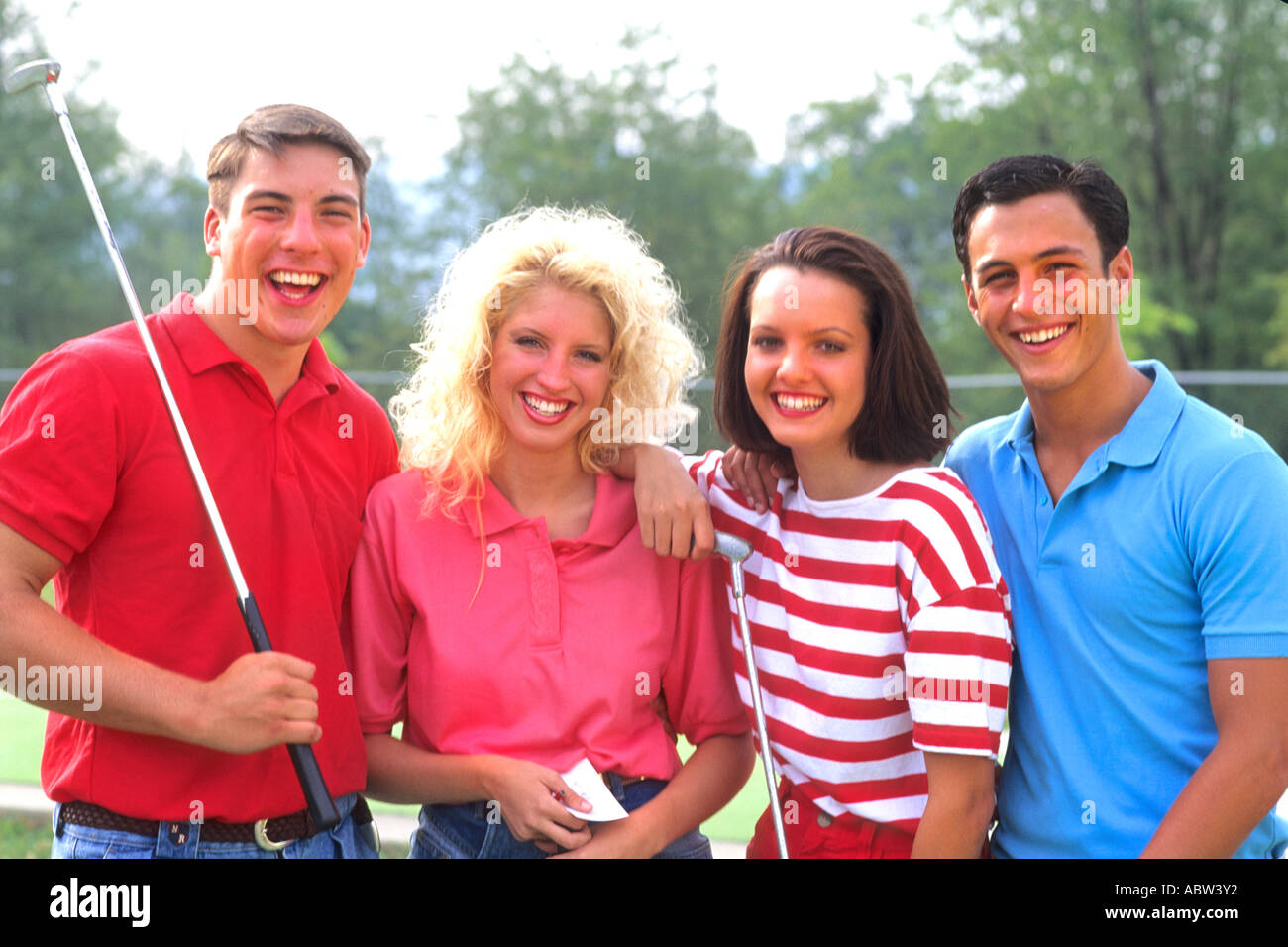 Teen couples relaxing and having fun while playing miniature golf ...