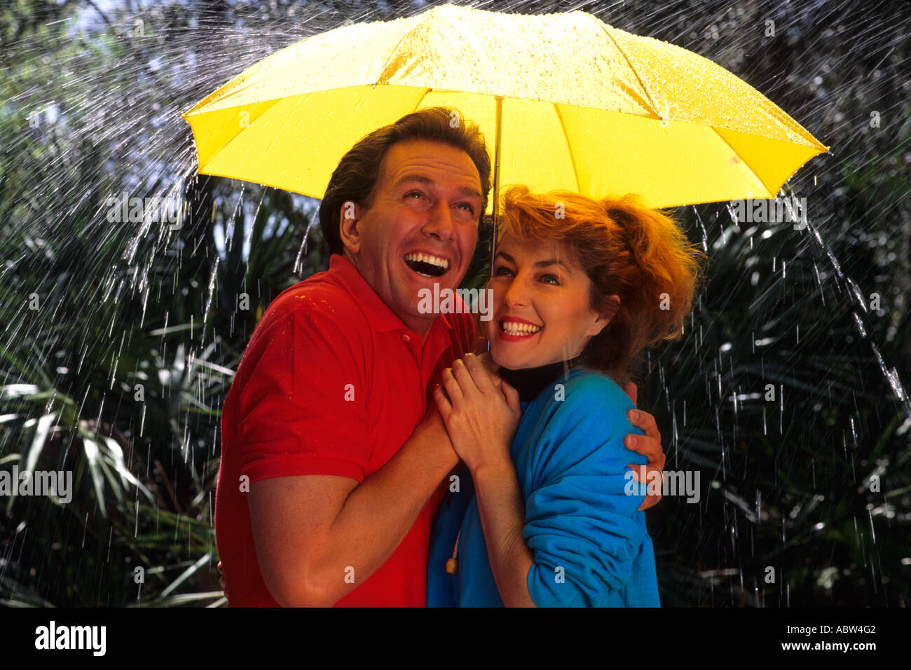 Couple huddle together under umbrella hi-res stock photography and ...