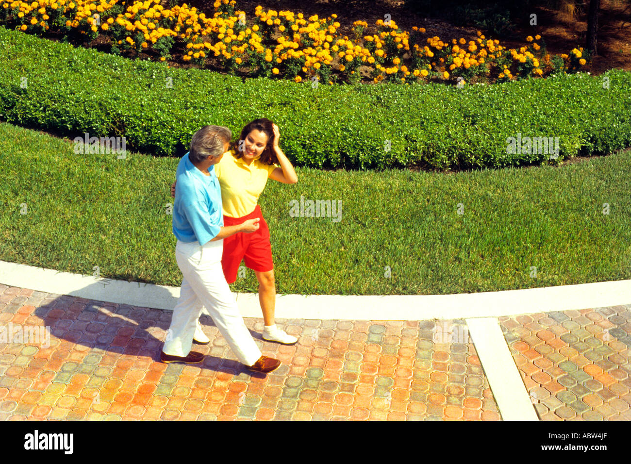 Couple taking a walk in an affluent community on bricks from aerial ...