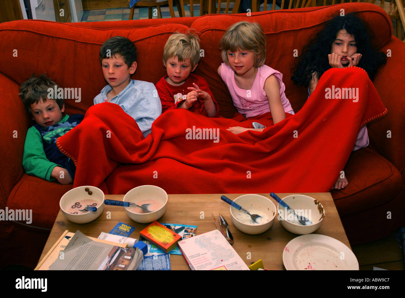 Children watching morning child television shows sitting on a sofa ...