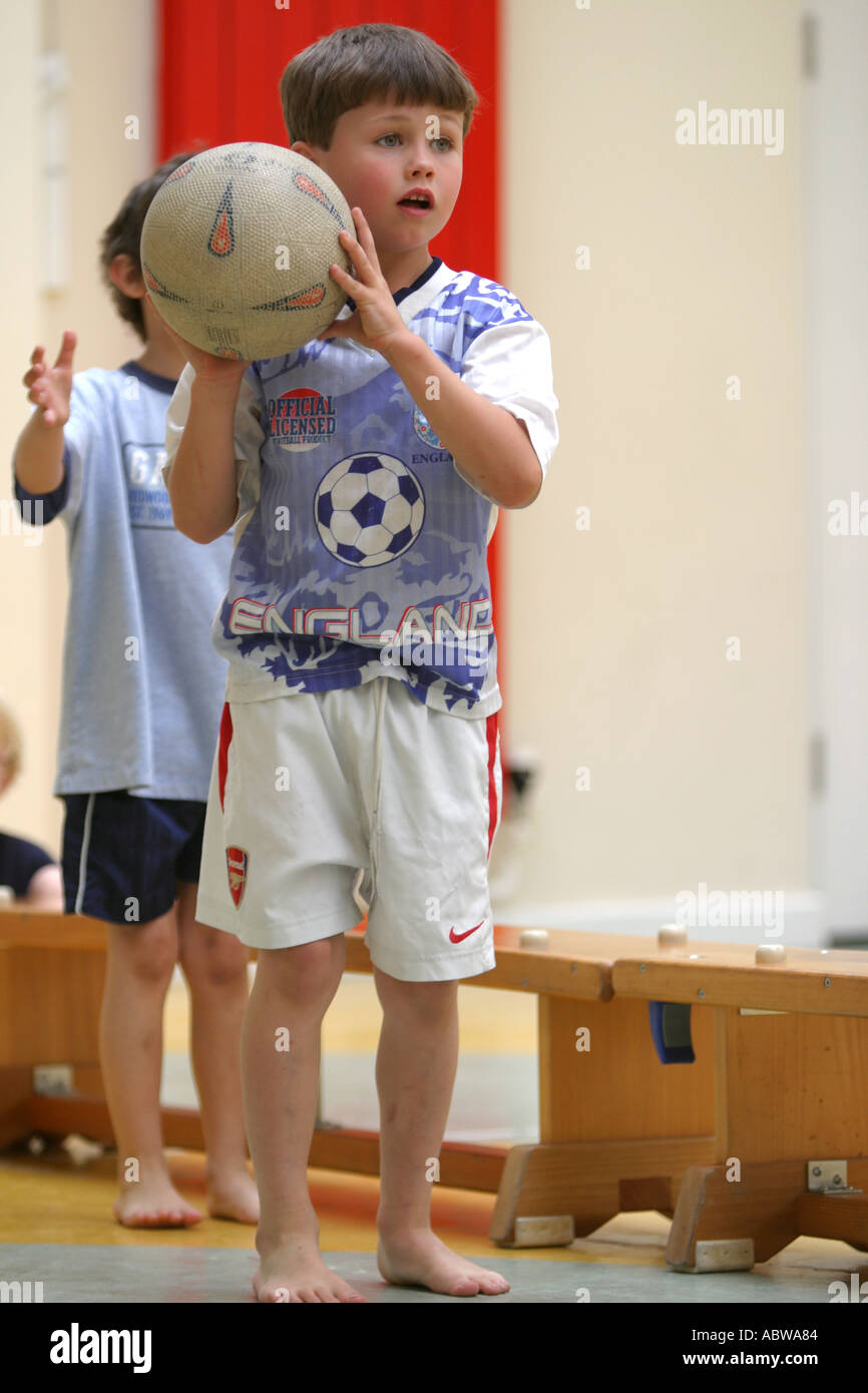 A boy holding a ball during a physical education lesson at a junior ...