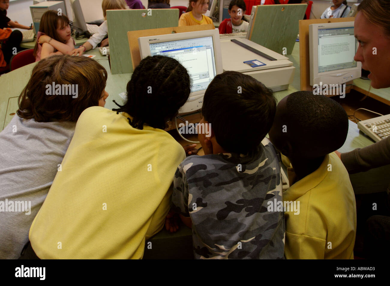 Boys surround a computer monitor during an information technology ...
