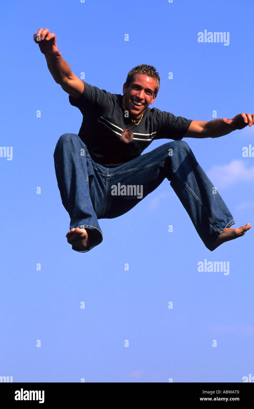 Teenage boy leaping in air with joy and action Stock Photo - Alamy