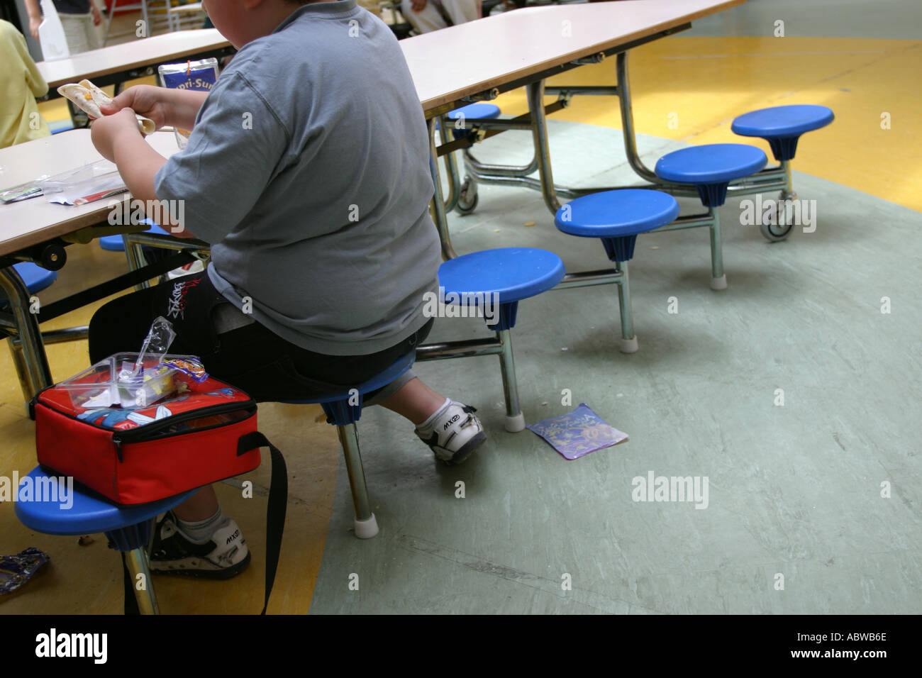 An overweight boy eats snacks for lunch at school, London, UK Stock ...