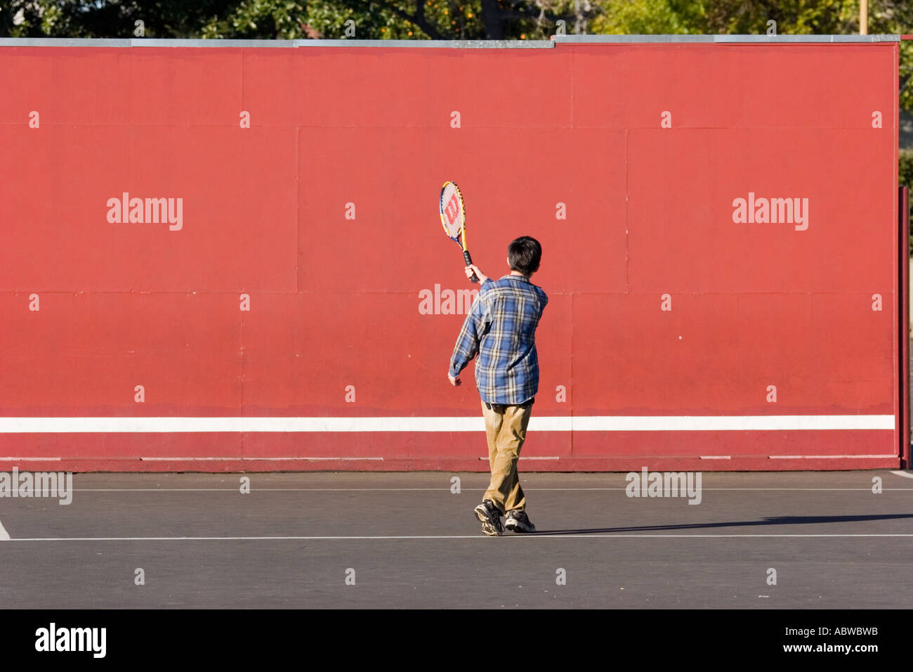 Boy Practices Tennis on Backboard Stock Photo - Alamy