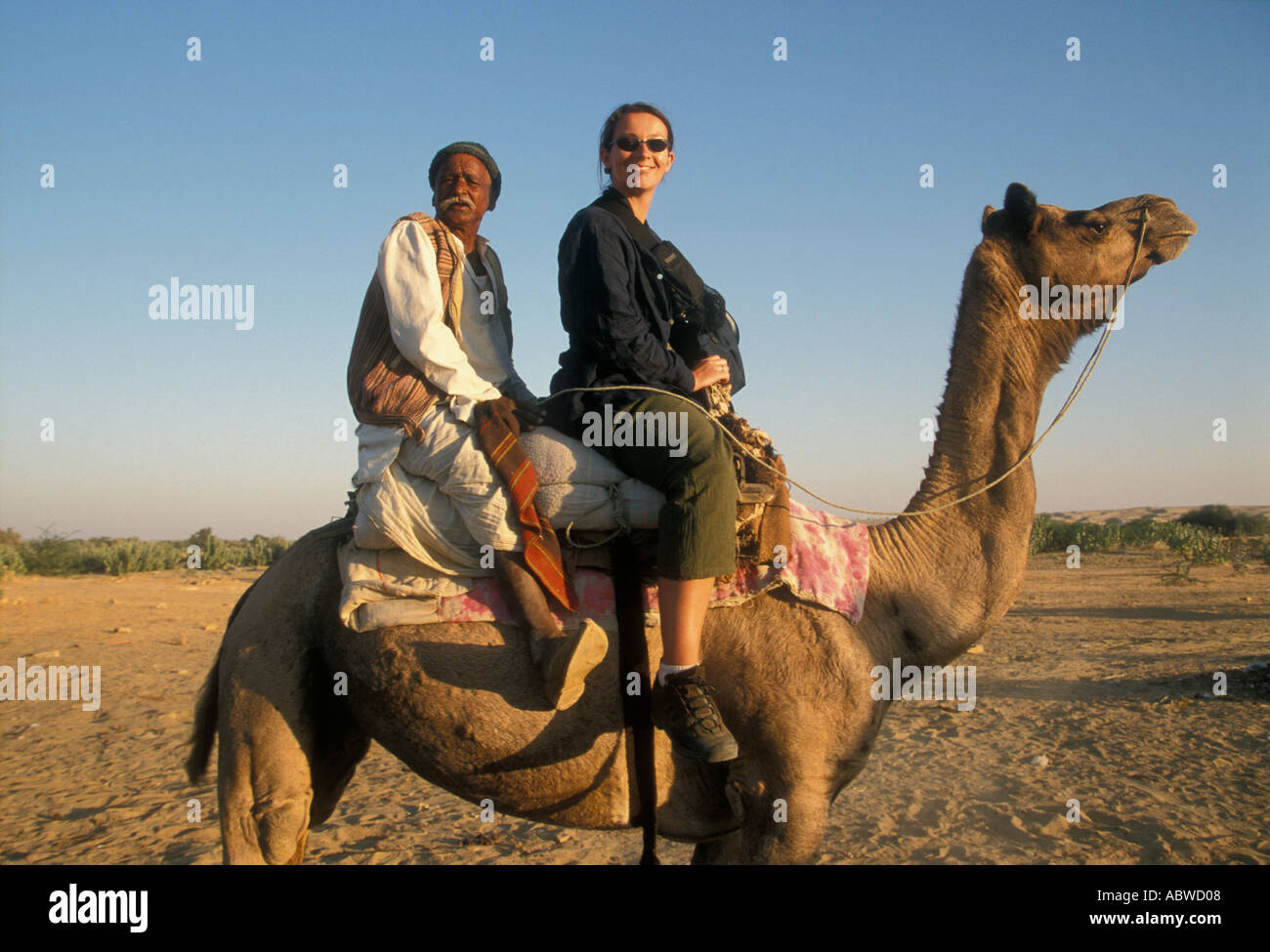Rajasthani Rachael on a camel with guide behind in the desert in ...