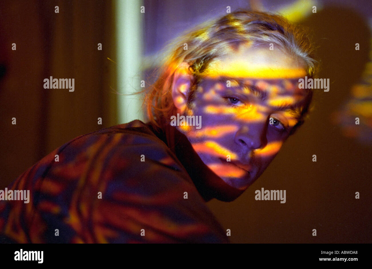 Man with coloured lights on face Stock Photo - Alamy