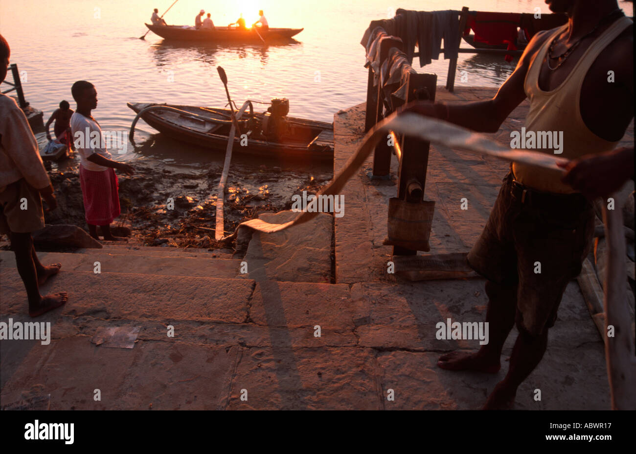 pulling a hose on the ganges varanasi india Stock Photo - Alamy