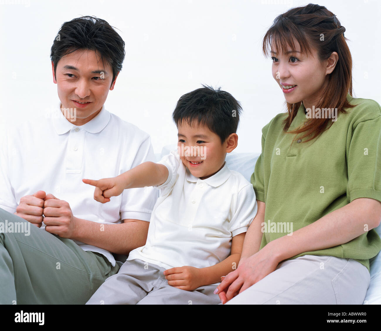 A small boy drawing attention of his parents by pointing his finger at ...