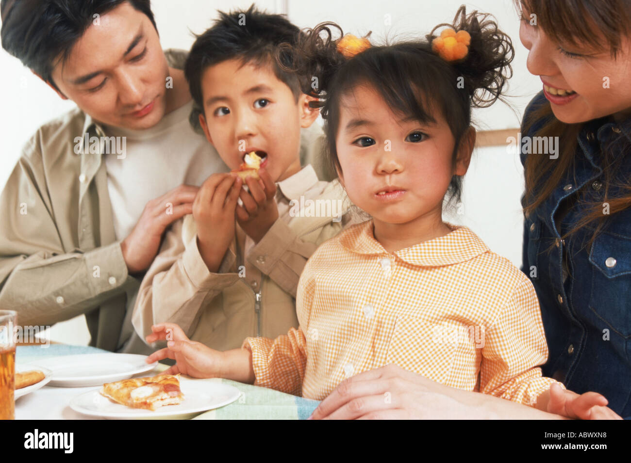 Family eating pizza at table Stock Photo - Alamy