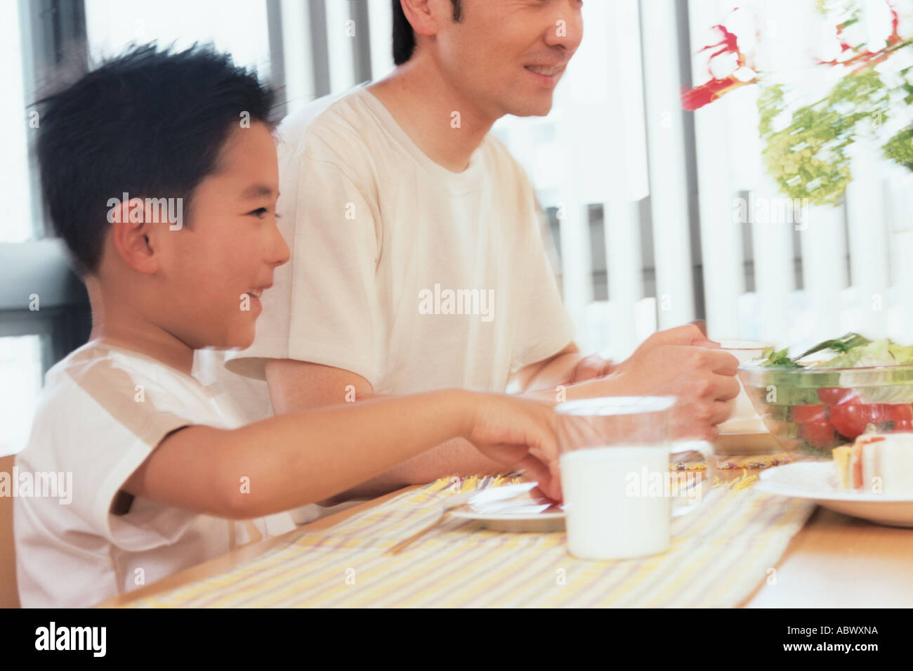 Side view of a boy smiling while having his meal Stock Photo - Alamy