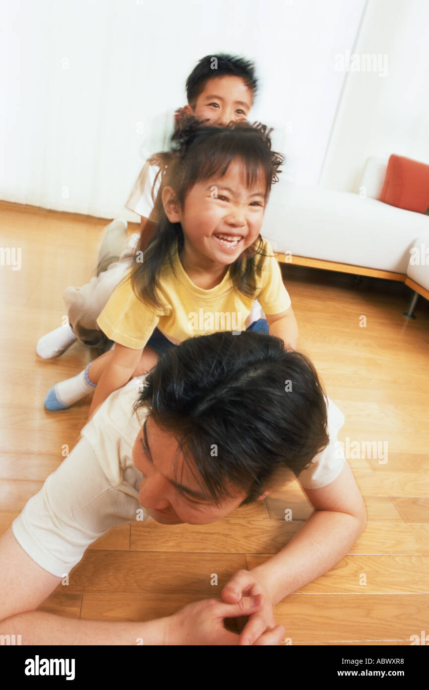 Two children sitting on their father s back Stock Photo - Alamy