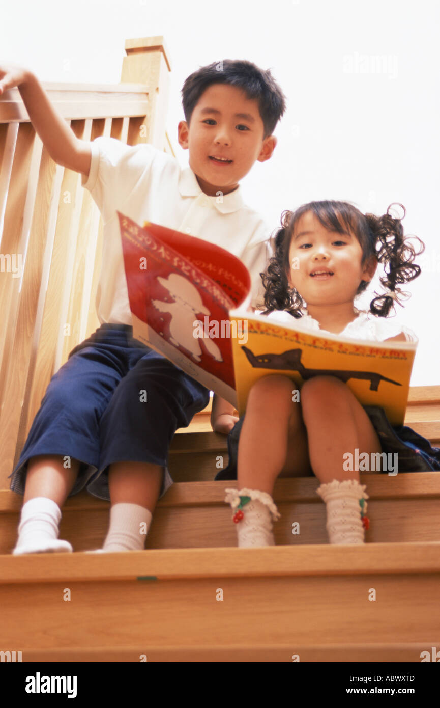 Two children reading a book Stock Photo - Alamy