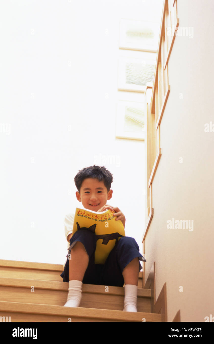 A small boy sitting on steps Stock Photo - Alamy