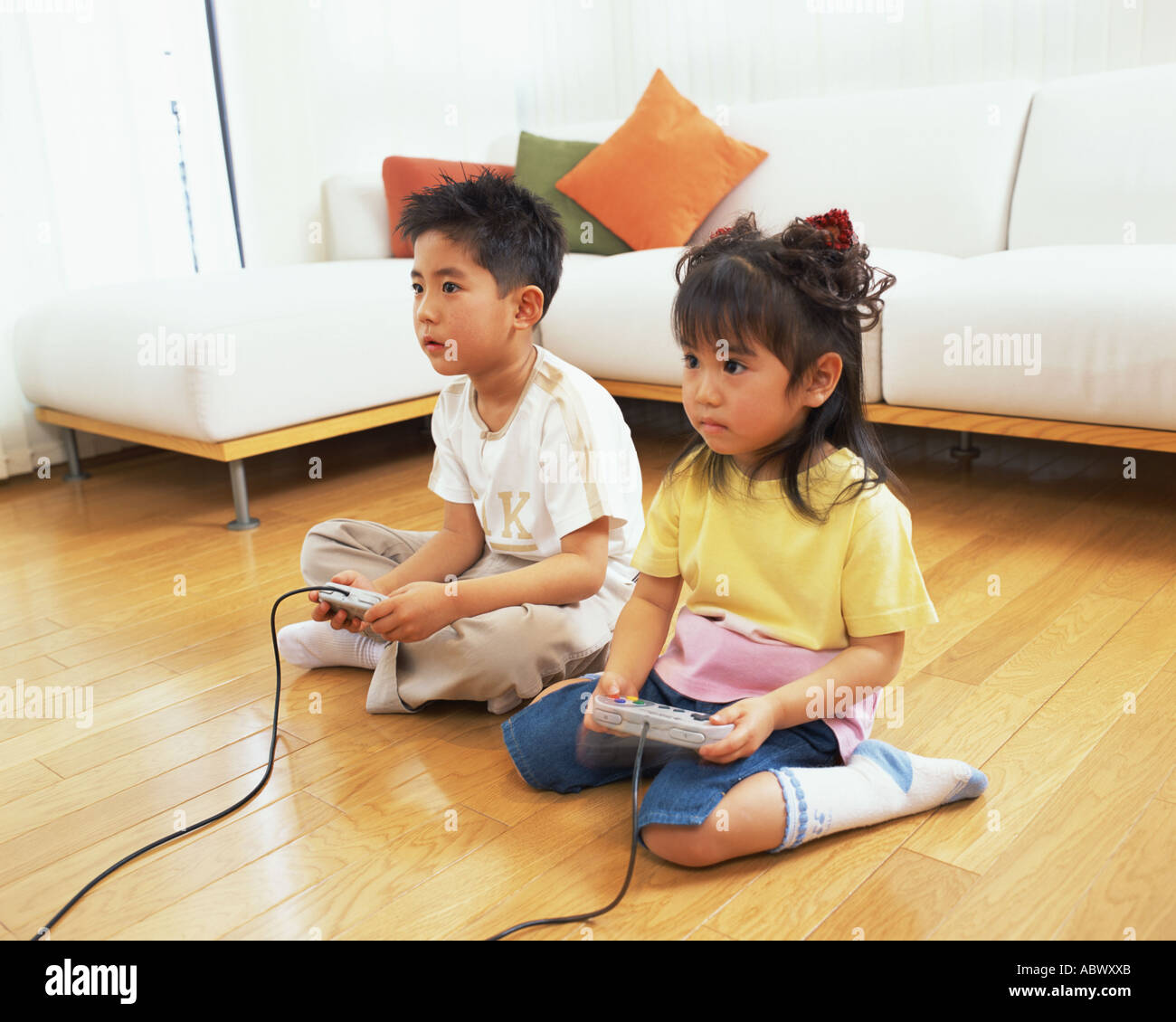 A small boy playing video game along with his sister Stock Photo - Alamy