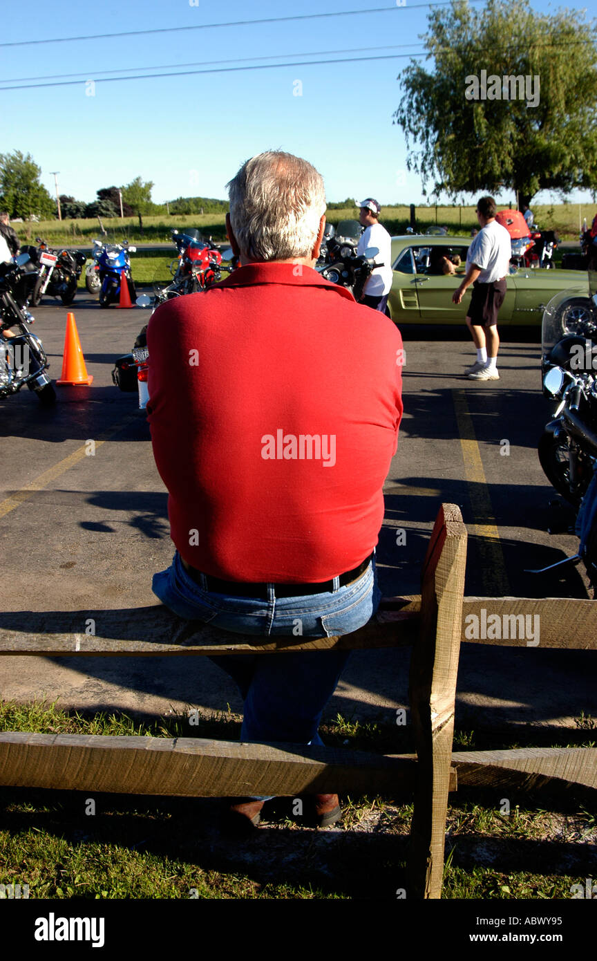 Man sitting on fence Stock Photo - Alamy