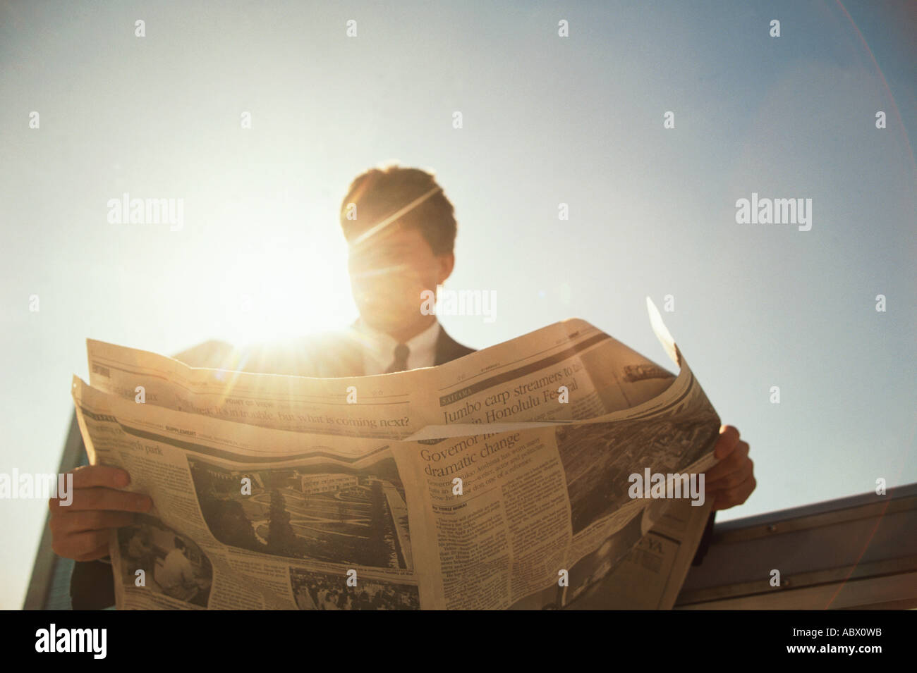 Low angle view of a person reading newspaper Stock Photo - Alamy