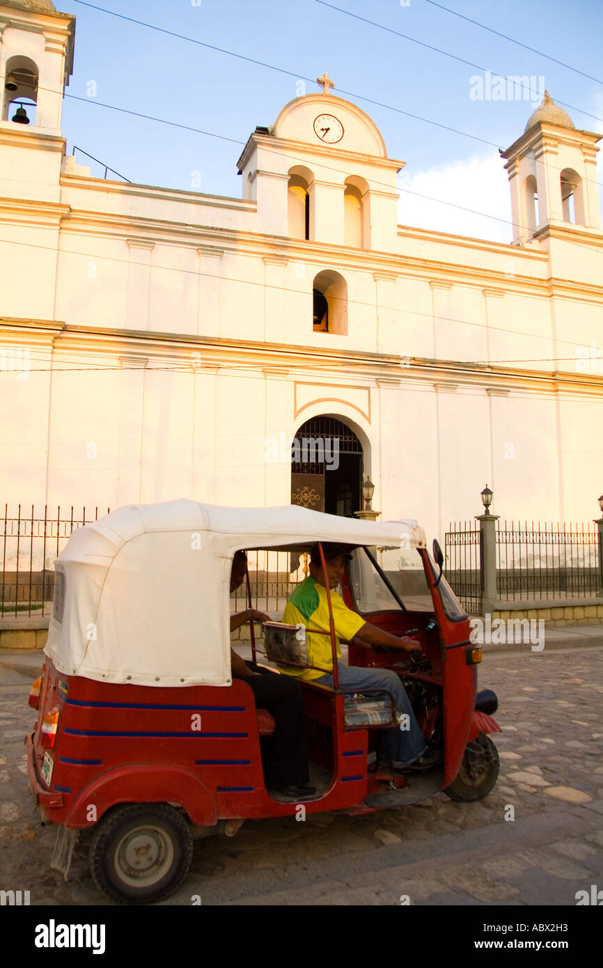 Coco Taxi with locals in front of main catholic cathedral in Copan ...