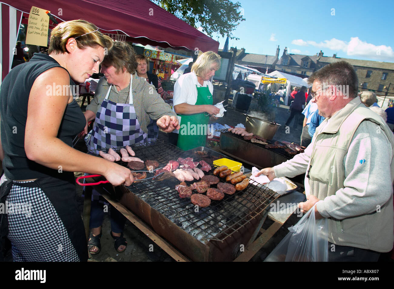 Barbecue chefs cooking burgers at a food stall at a country fair in ...
