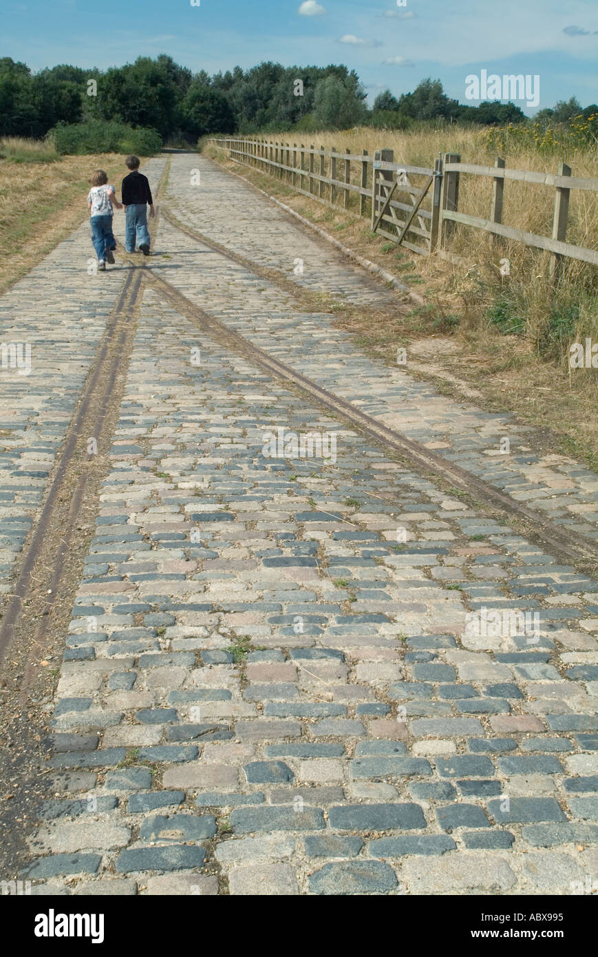 two children walking on cobblestone path Stock Photo - Alamy