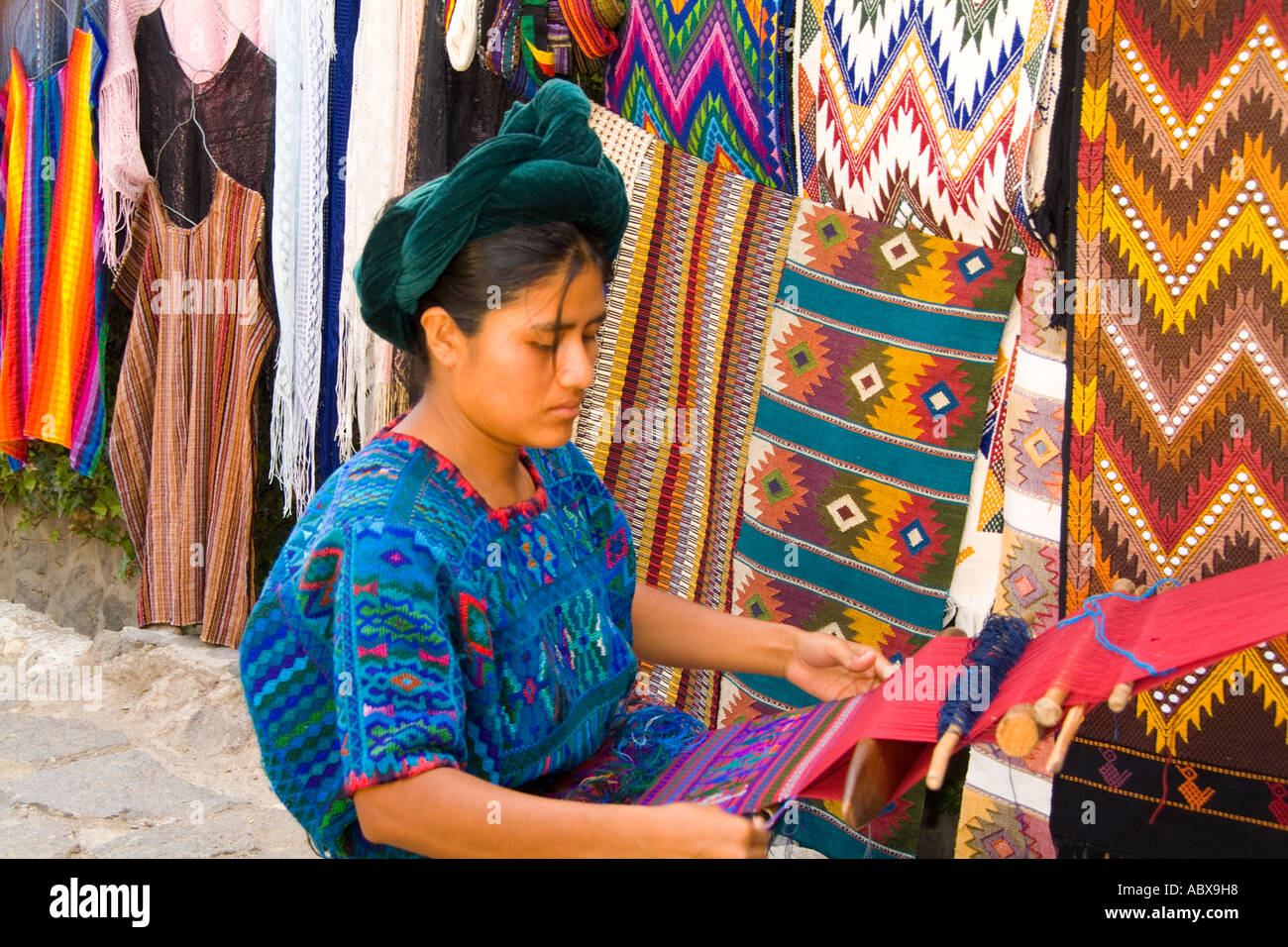 Woman using hand loom weaving artwork outside in Villa Santa Catarina ...