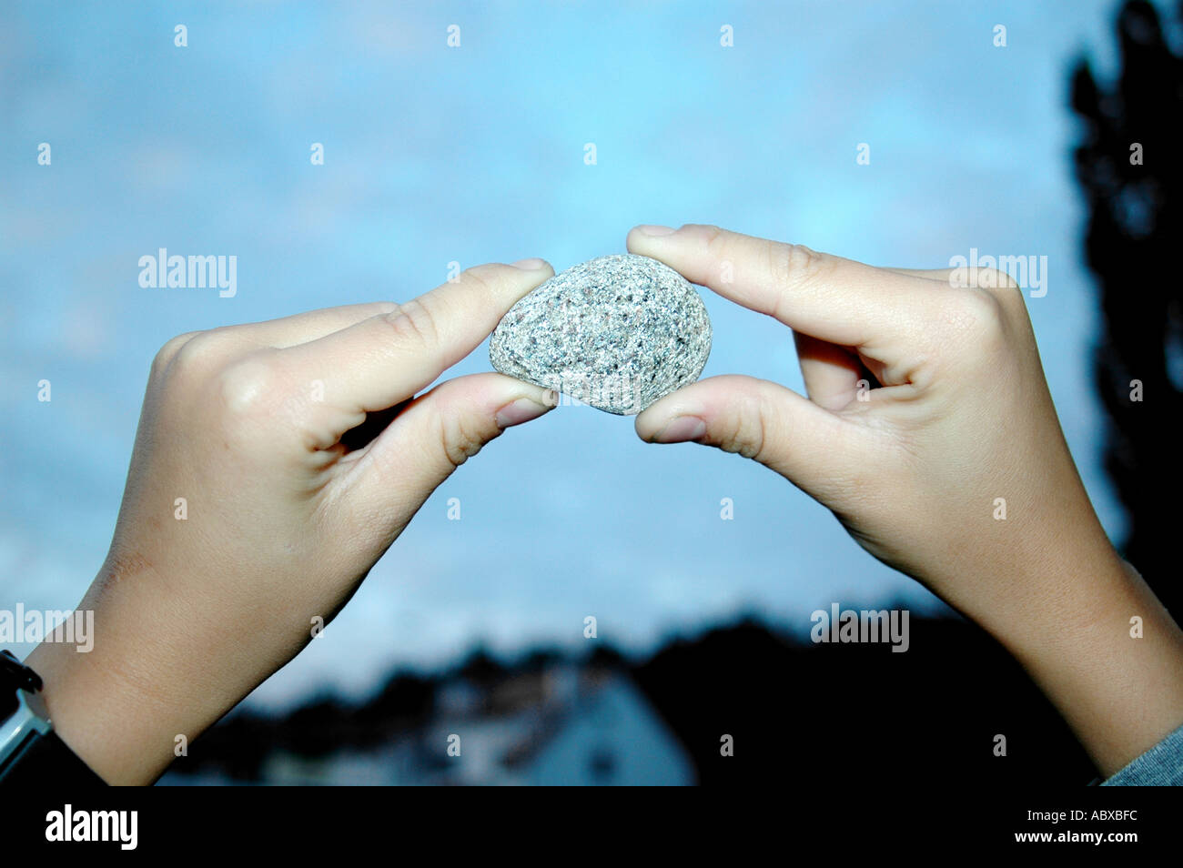 Hands holding stone talisman Stock Photo - Alamy