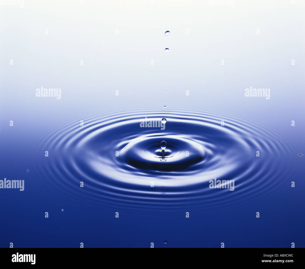 Water droplet falling on surface of water Stock Photo - Alamy
