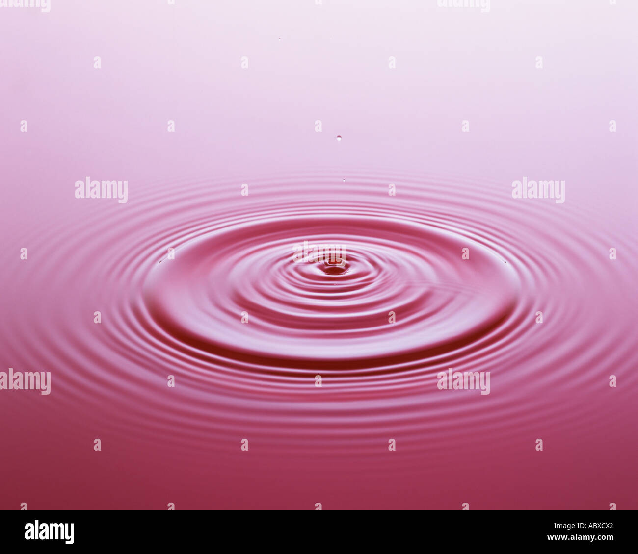 Water droplet falling on surface of water Stock Photo - Alamy