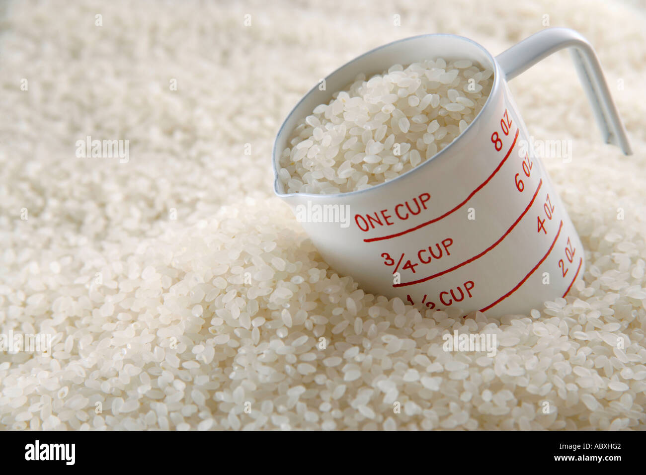 Uncooked rice and measuring jug Stock Photo - Alamy