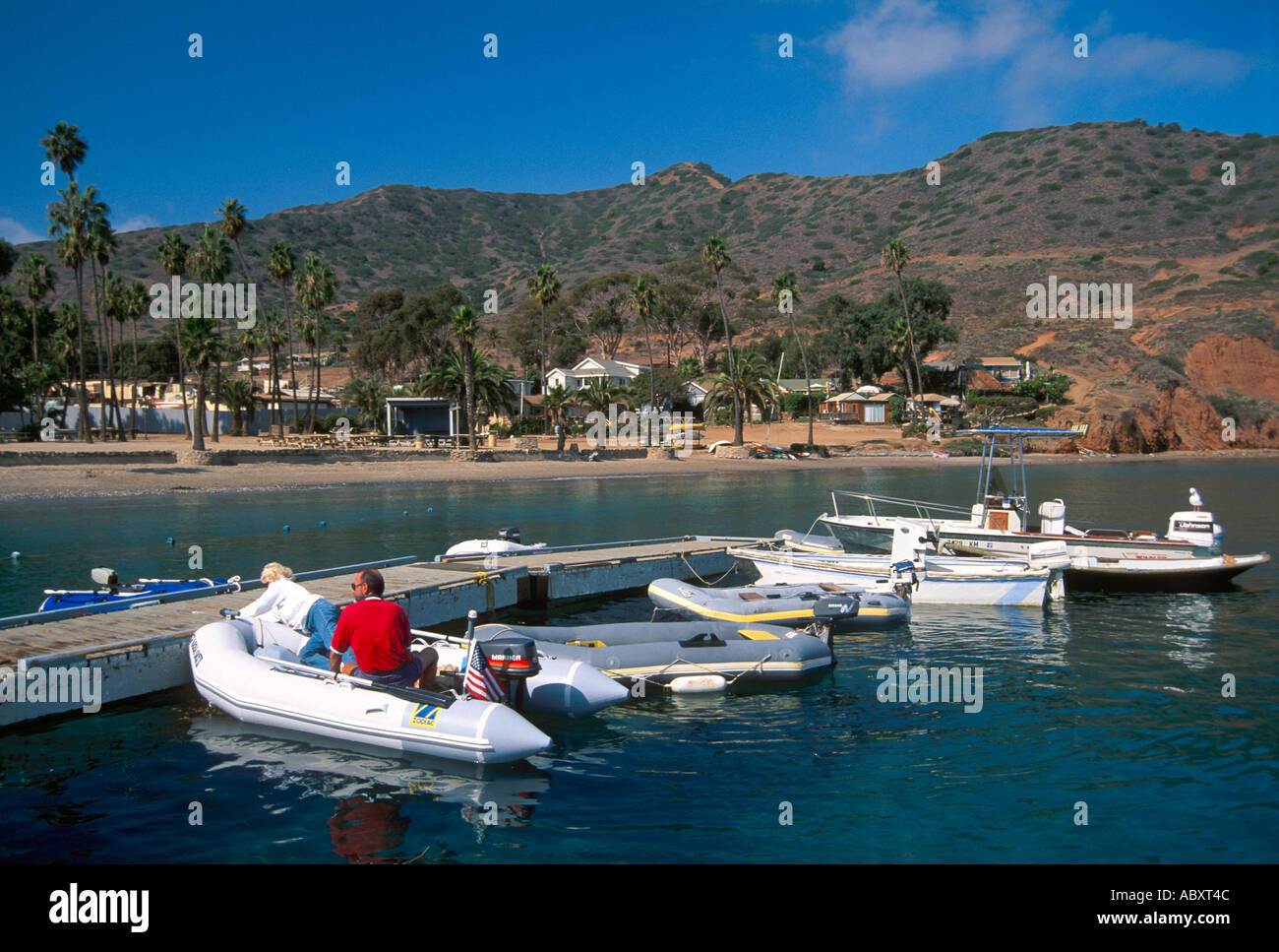 Couple in rubber zodiac raft dingy boat pulling into dock at Two ...