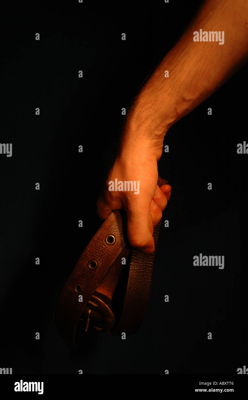 Man holding belt illustrating domestic violence Stock Photo - Alamy