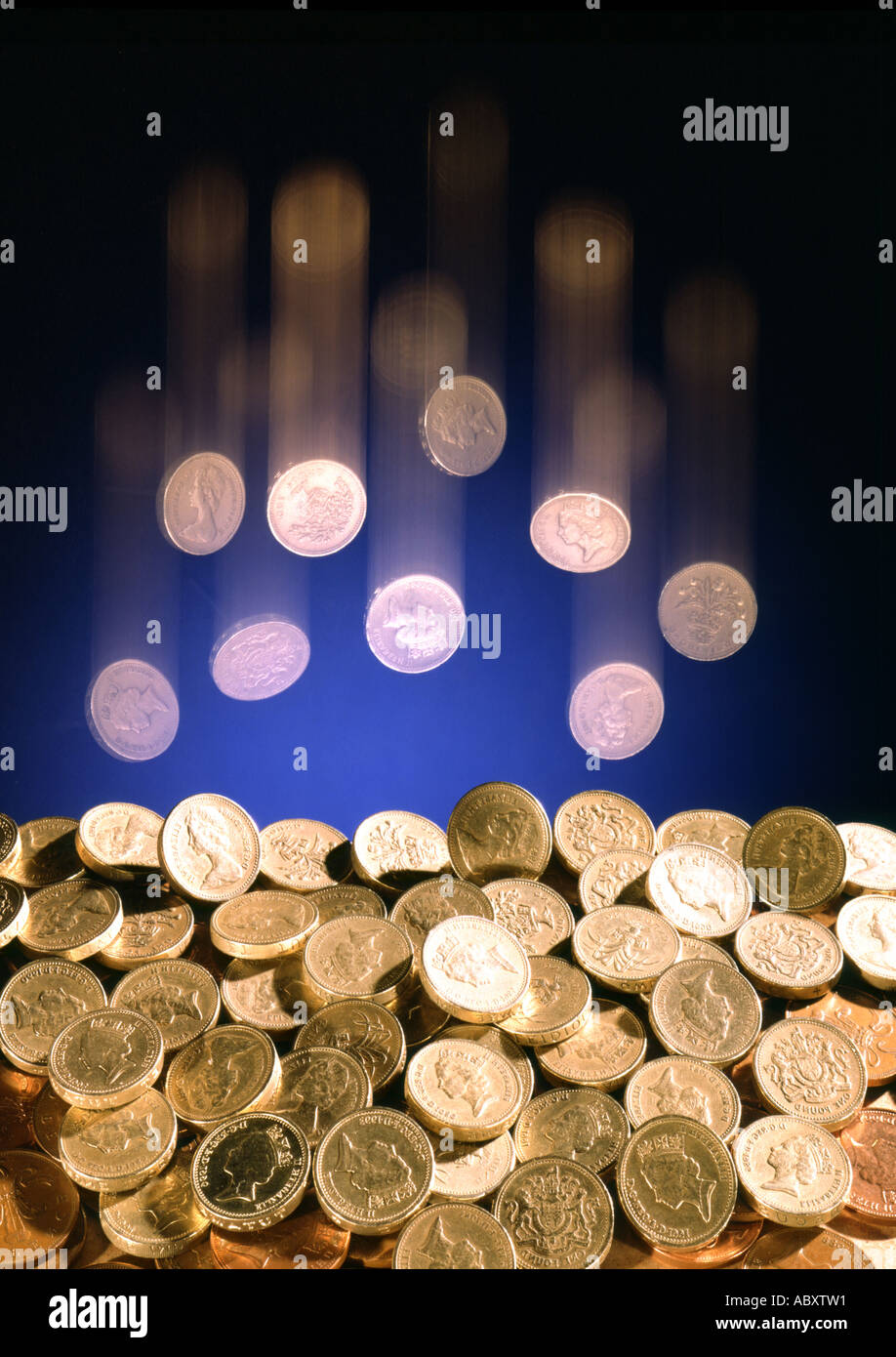 Falling £1 coins on a blue vignetted background Stock Photo - Alamy