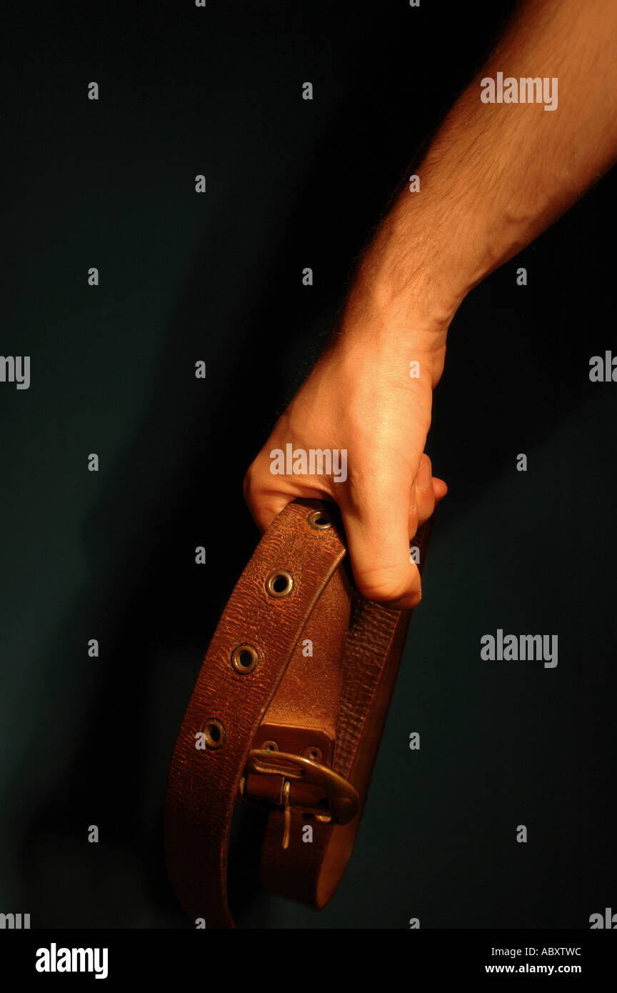 Man holding belt illustrating domestic violence Stock Photo - Alamy