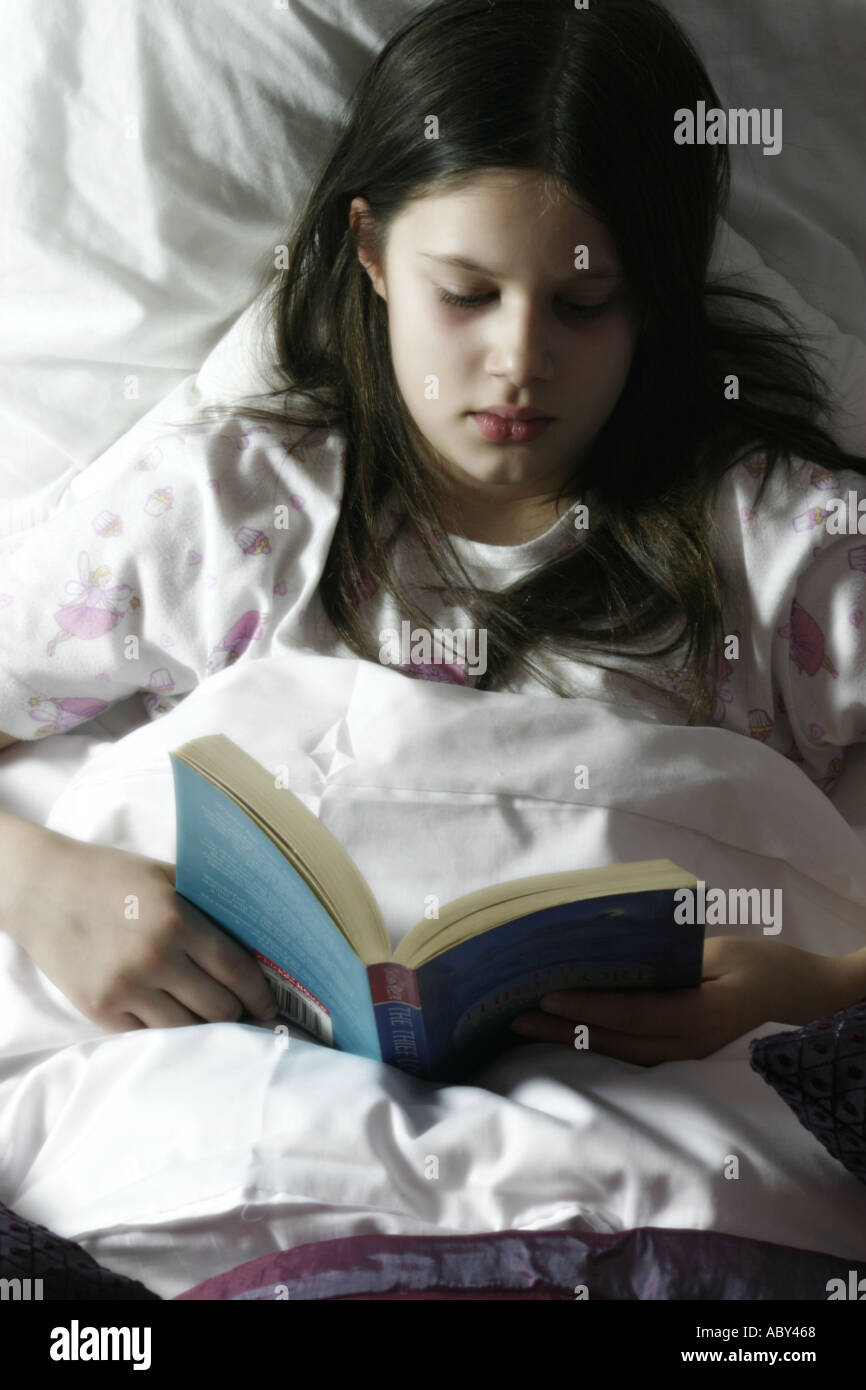 Young girl aged ten reads a book before bedtime Stock Photo - Alamy